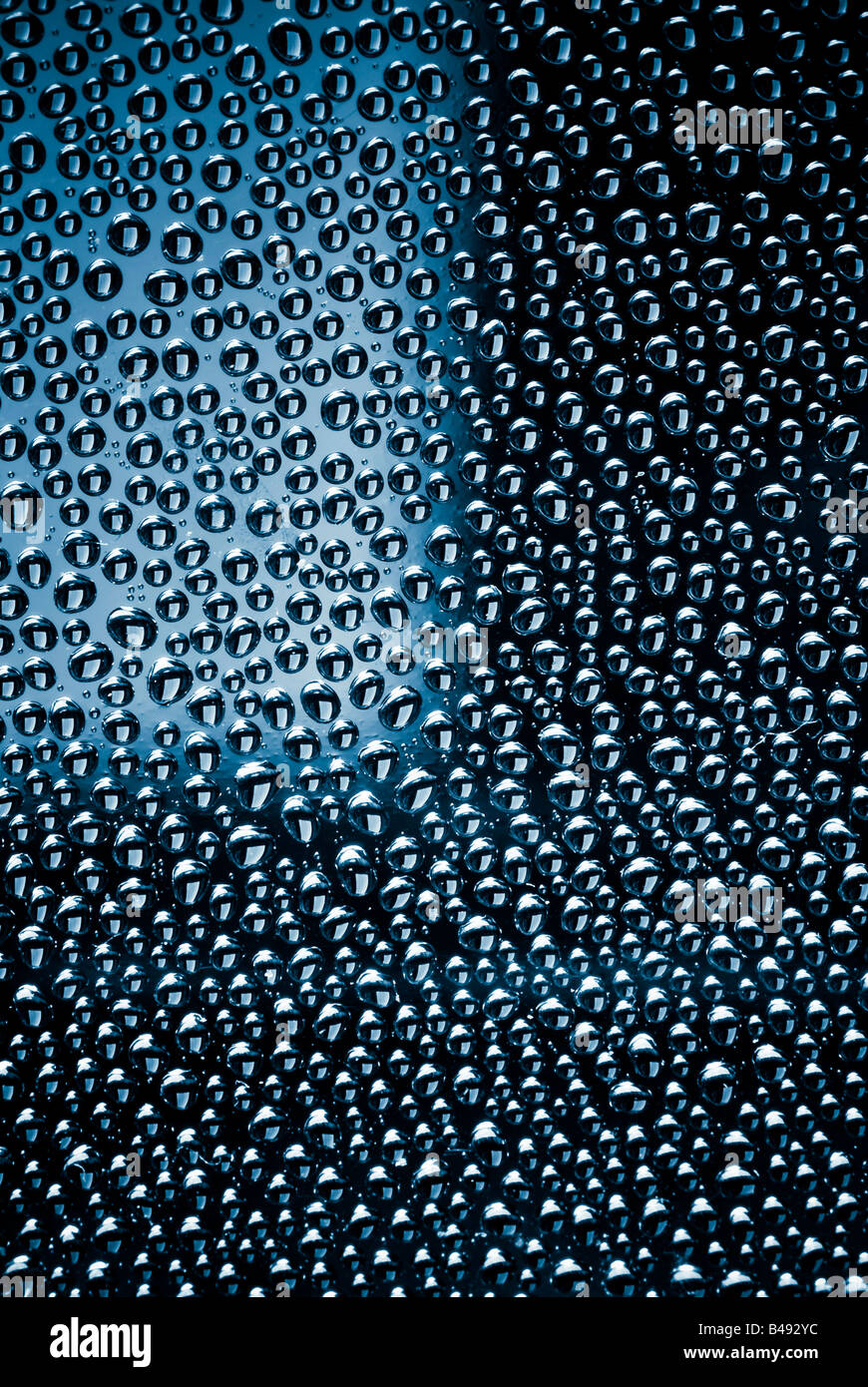 Water droplets on glas with a lit doorway behind it Stock Photo - Alamy