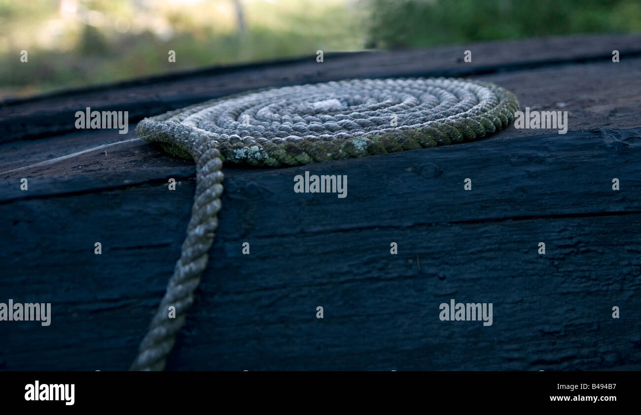 A rope neatly rolled up on a tared boat Stock Photo - Alamy