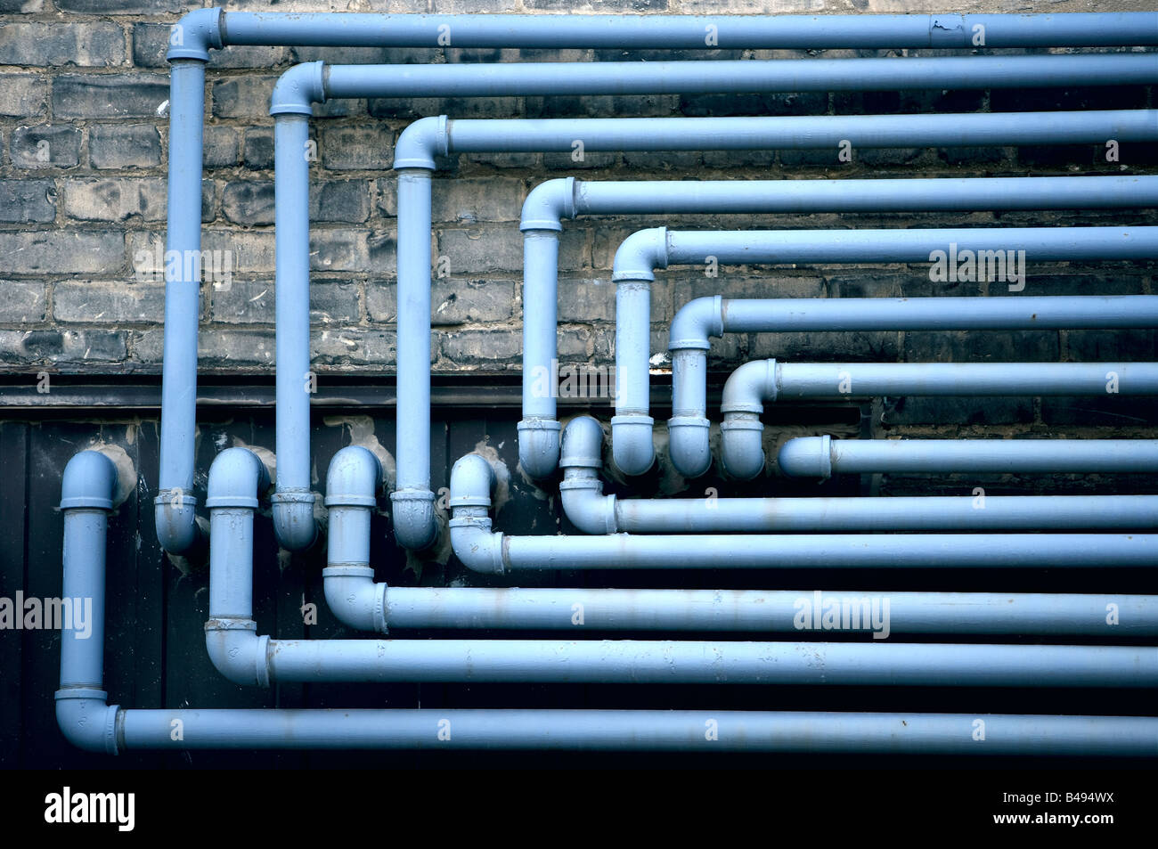 Many painted pipes on the side of a brick building Stock Photo - Alamy