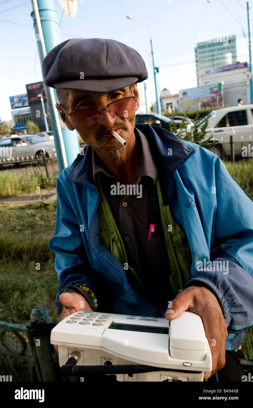 A Mongolian man with his public telephone in his hands. it is possible ...