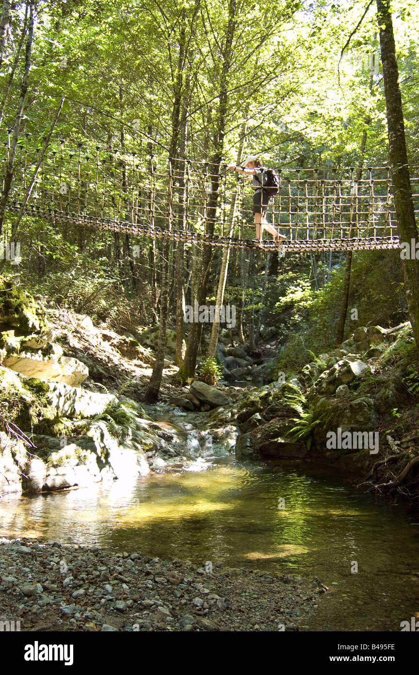 Woman crossing a rope bridge hi-res stock photography and images - Alamy