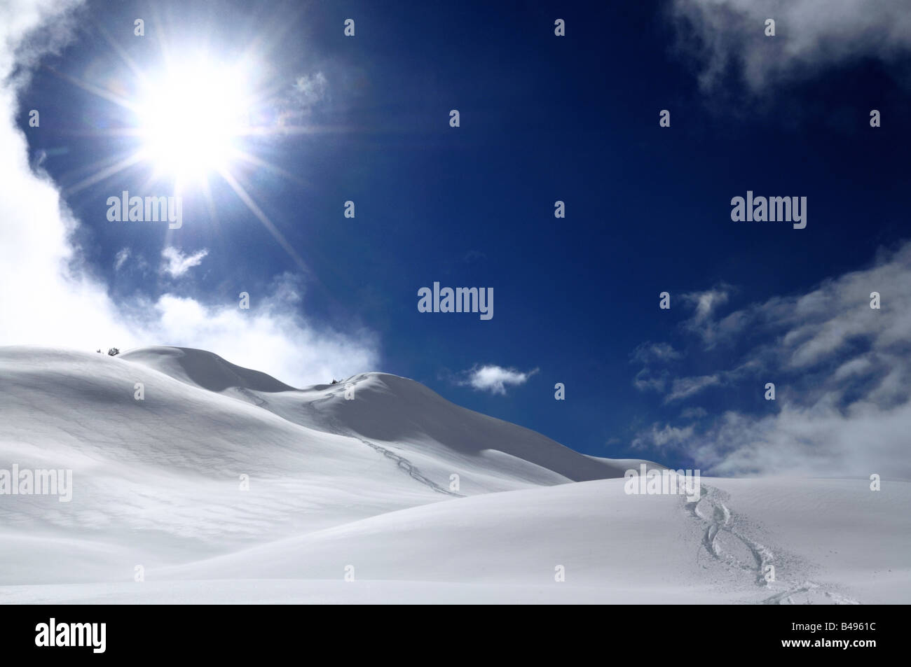 Two figure eight ski tracks in powder over rolling terrain with a ...