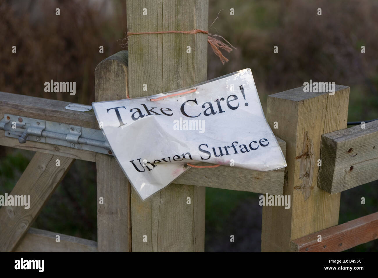 sign on gate take care uneven surface Stock Photo - Alamy