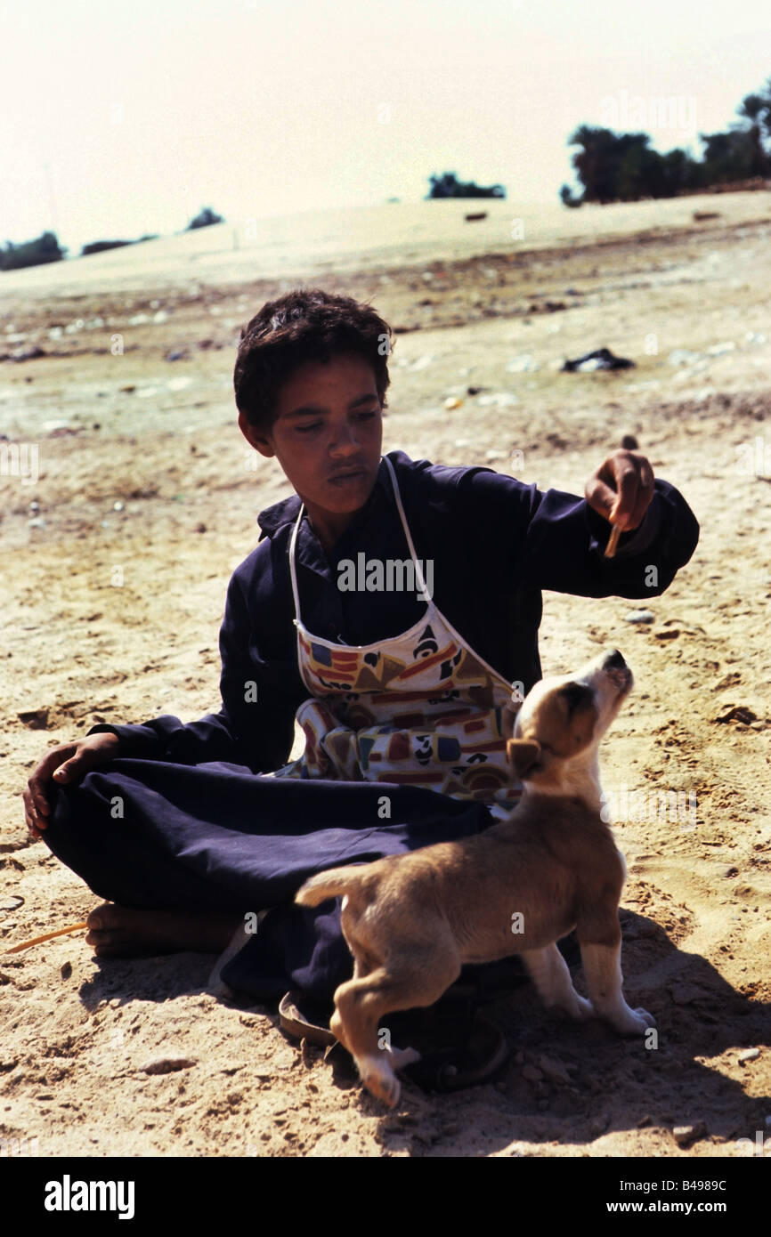 A Bedouin boy plays with his pet dog on the res sea coast of the Sinai ...