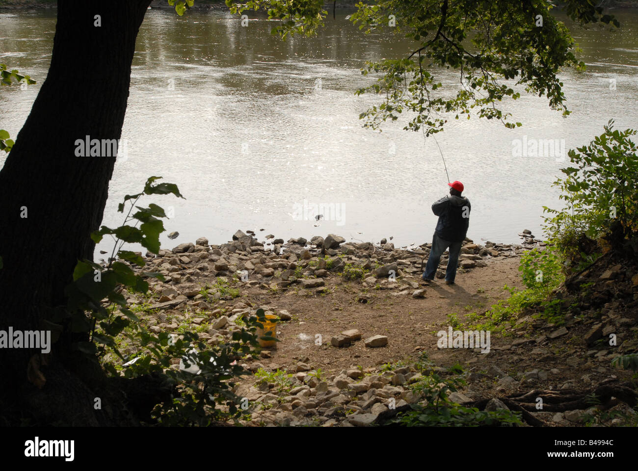 An African American man fishing in a river Stock Photo - Alamy