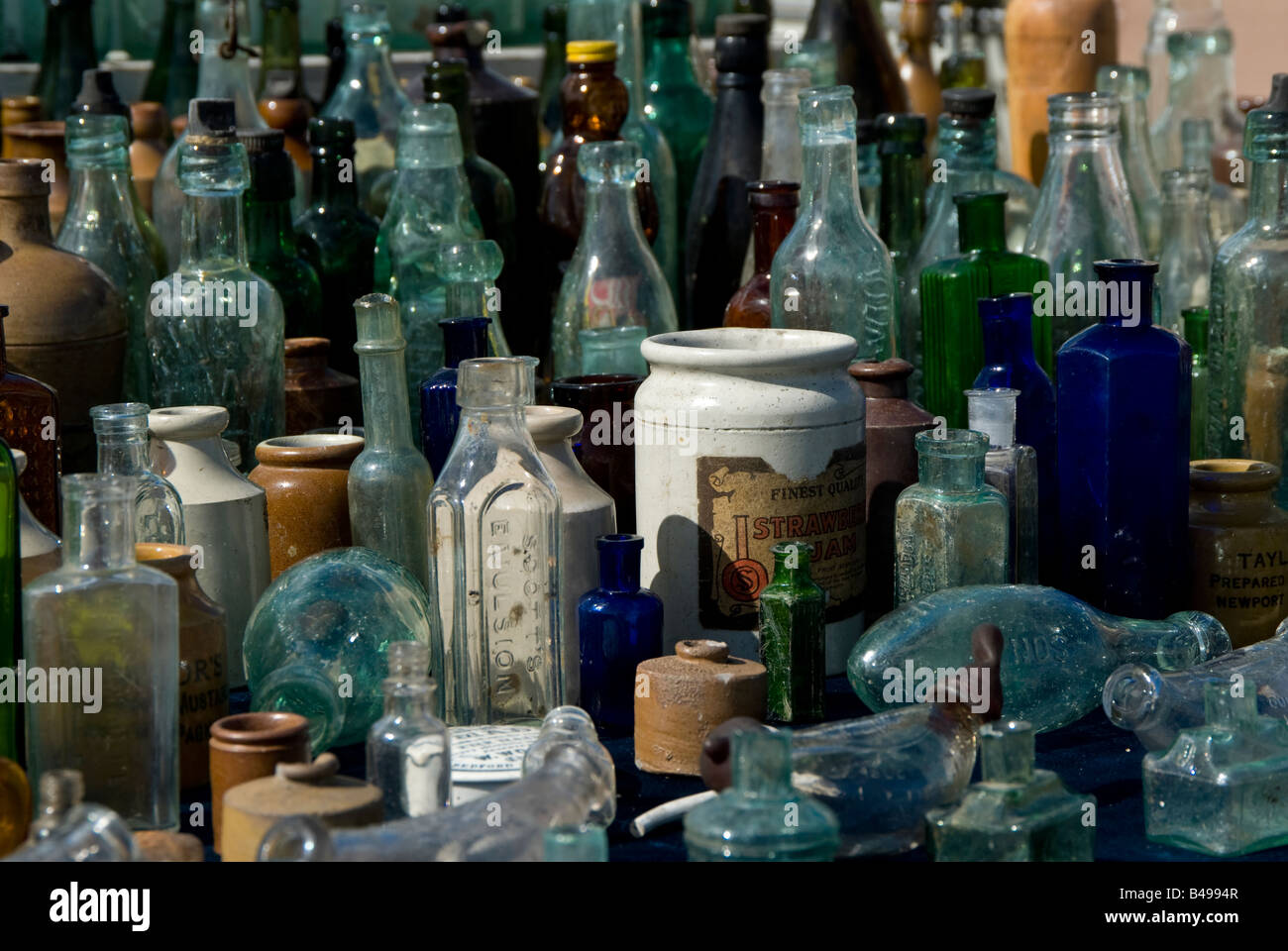 A collection of vintage bottles, pots and jars displayed by a collector ...