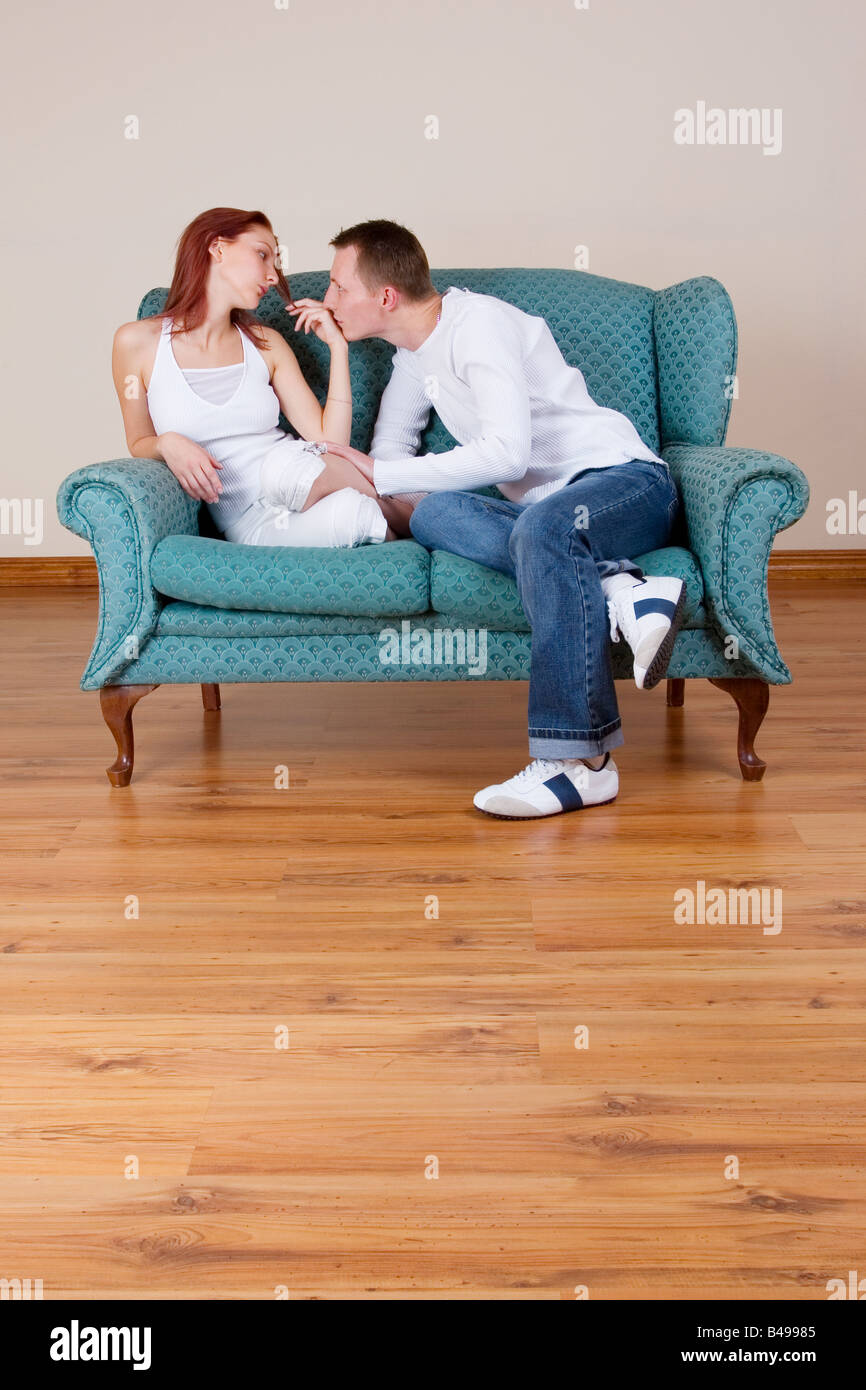 Woman and boyfriend sitting on couch Stock Photo - Alamy