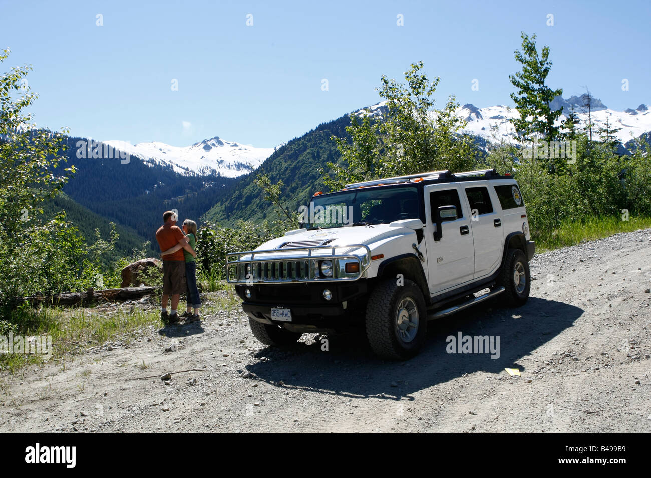 couple outdoors touring with a hummer off road in Whistler BC Stock ...