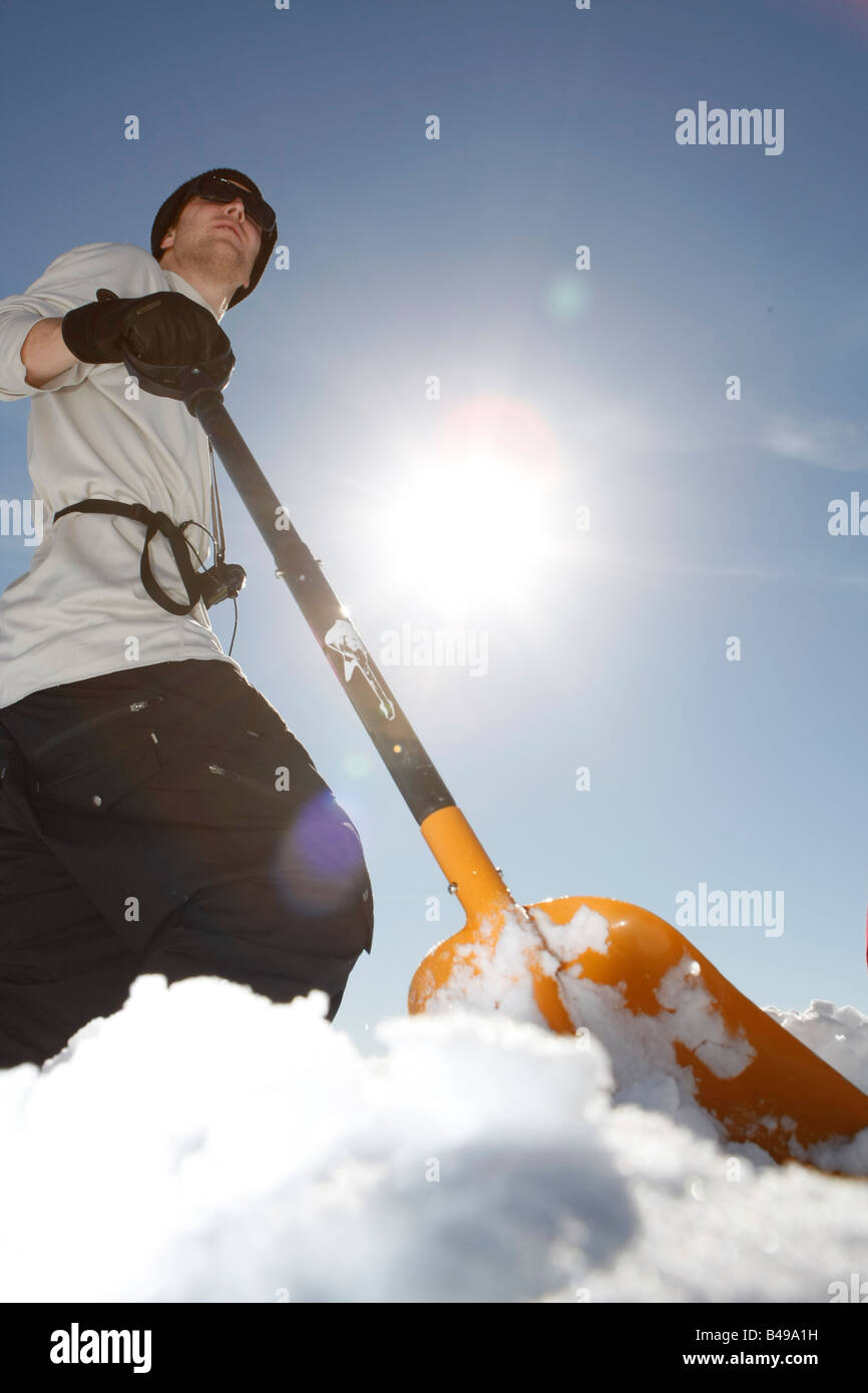 snowboarder shoveling snow building a kicker jump Stock Photo - Alamy