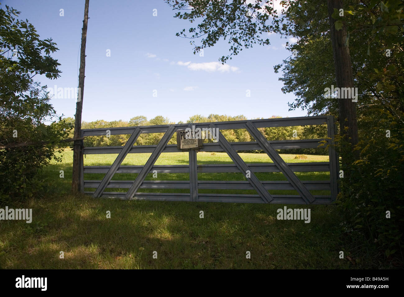 Photograph of a metal fence in front of a field Stock Photo - Alamy