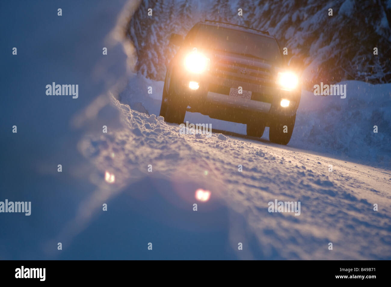 truck at night on a snowy road with lights on Stock Photo - Alamy
