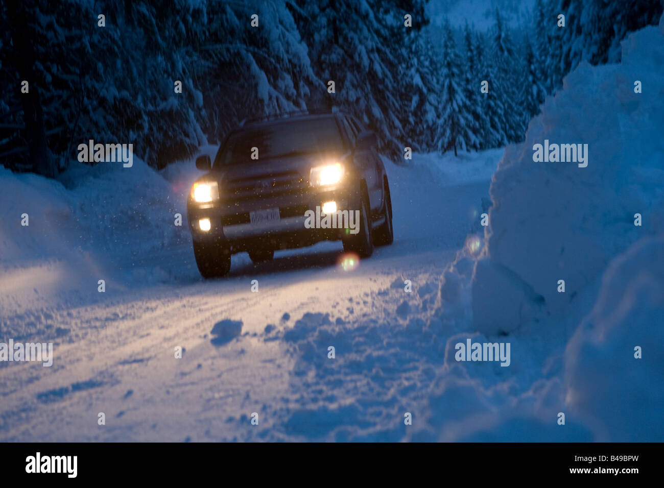 truck at night on a snowy road with lights on Stock Photo - Alamy