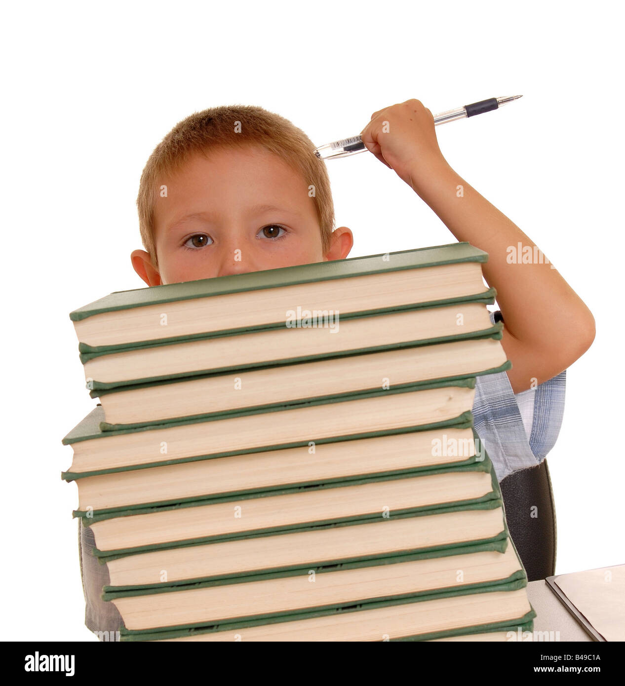 Young boy studying with a large pile of books Stock Photo - Alamy