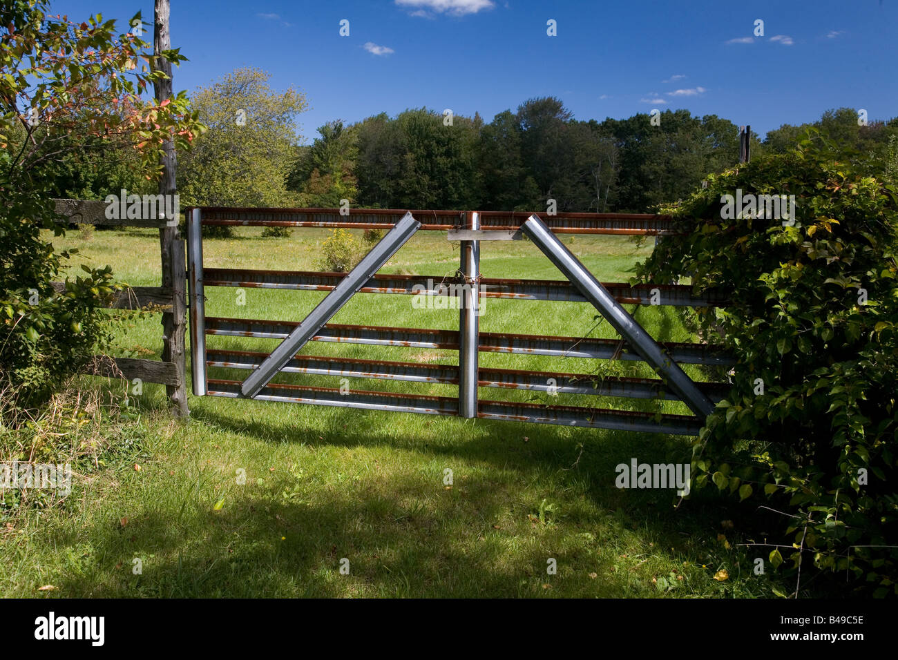Photograph of a metal fence in front of a field Stock Photo - Alamy