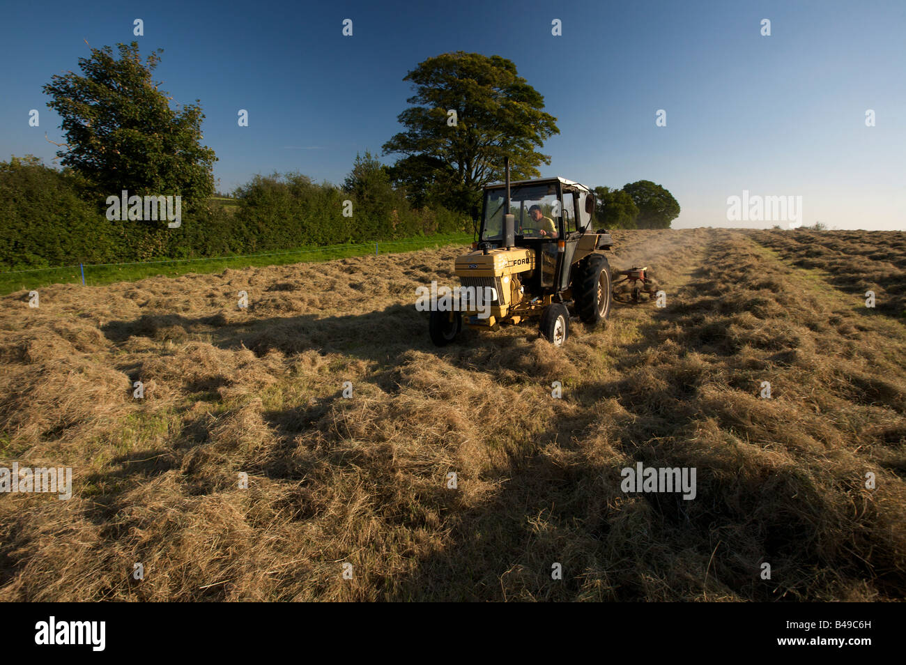 Tractor turning Hay UK Stock Photo - Alamy