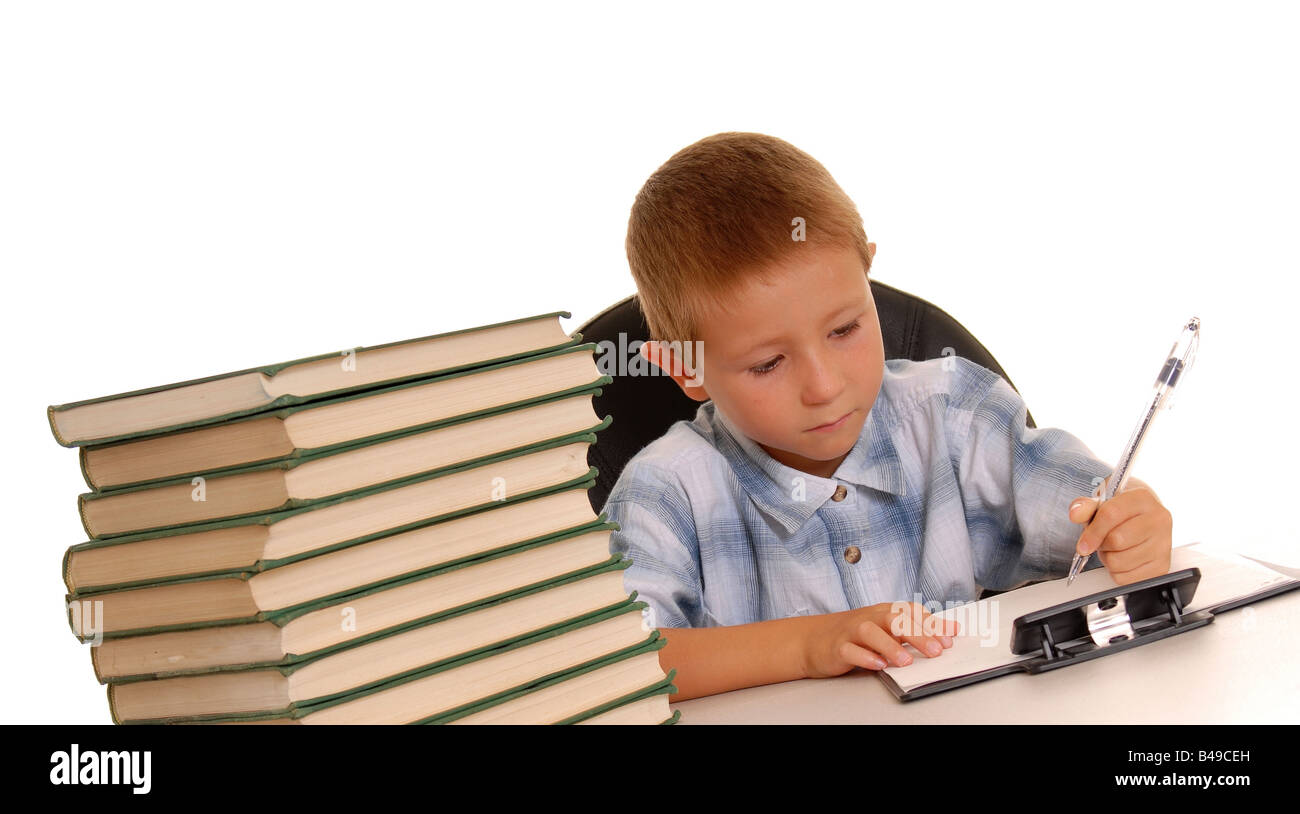 Young boy studying with a large pile of books Stock Photo - Alamy