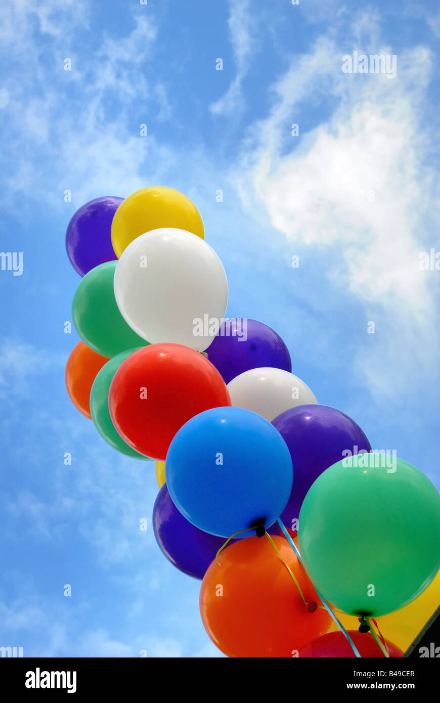 A group of balloons in rainbow colors float against a cloudy sky Stock ...