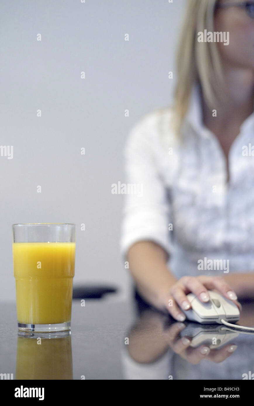 Woman working on a computer and a glass of orange juice Stock Photo - Alamy