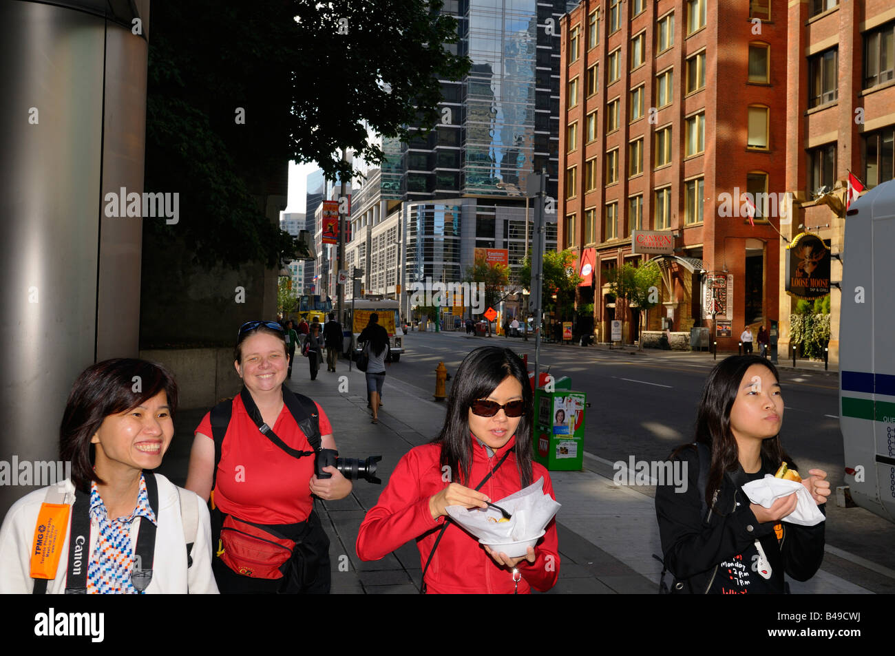 Group of female tourists walking on Front Street in downtown Toronto ...