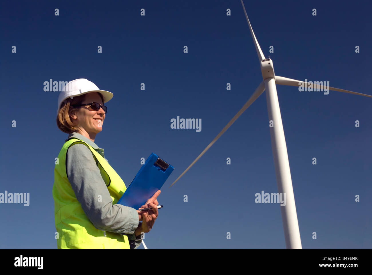 Female engineer next to wind turbine wind farm Stock Photo - Alamy