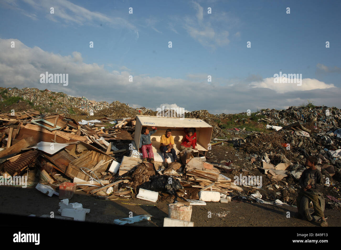 Roma gypsy children sitting in a box at Share, a slum next to a rubbish ...