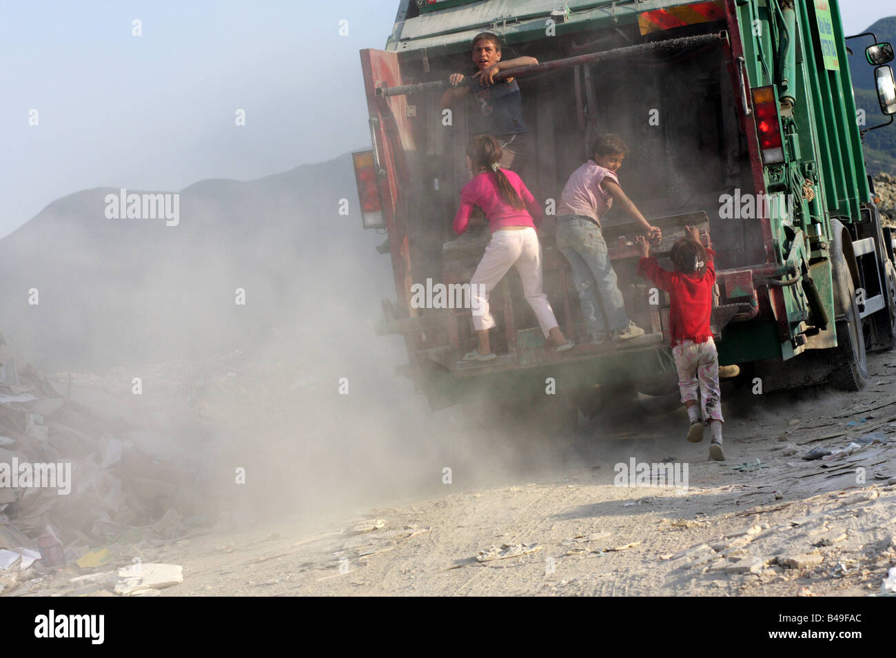 Children riding a dumpster in Sharre, a slum next to a rubbish dump on ...