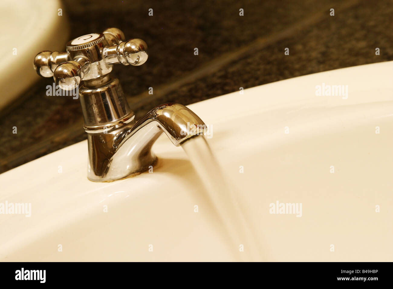 Tap and basin in bathroom with running water Stock Photo - Alamy