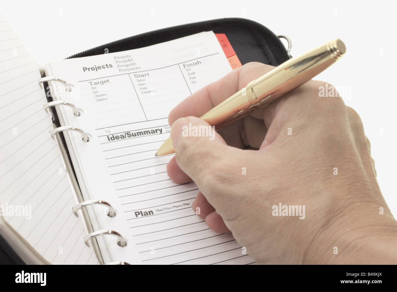 Hand holding pen writing on open organizer on white background Stock ...