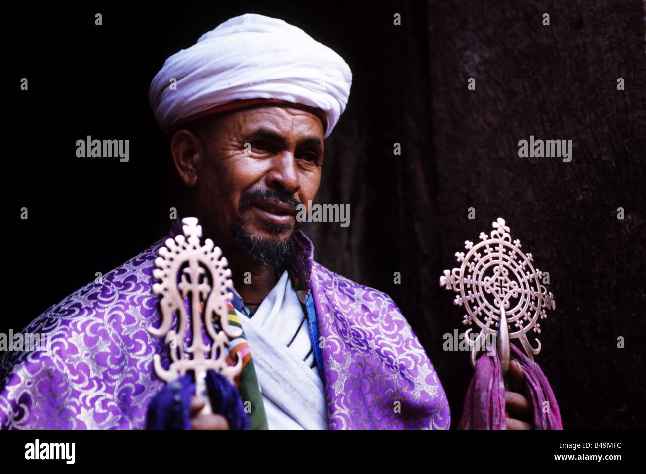 An Ethiopian Orthodox priest stands near one of Lalibela's old carved ...