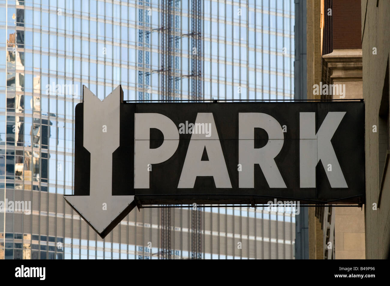 Park sign showing arrow with building in background Stock Photo - Alamy