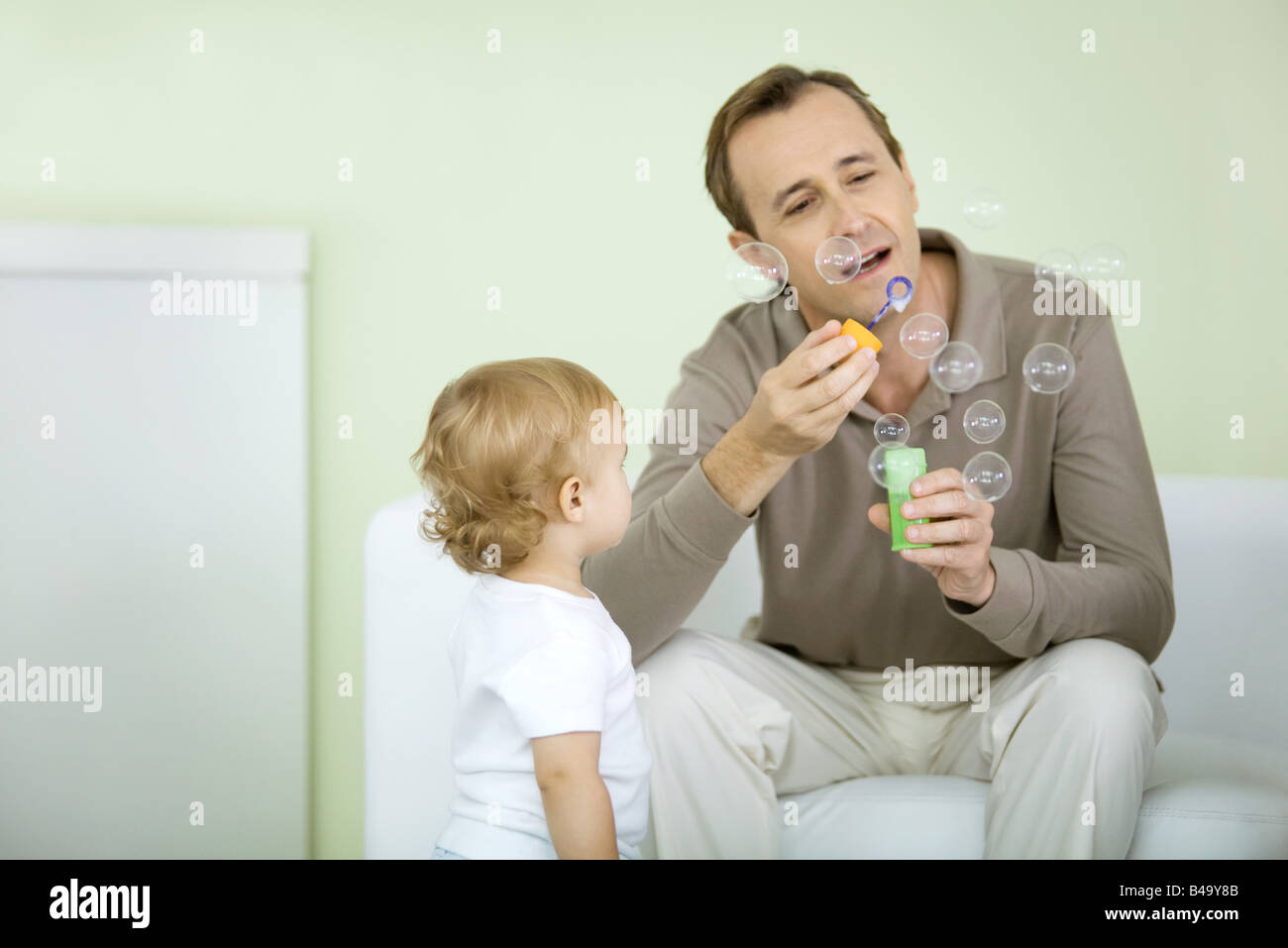 Father and toddler blowing bubbles together Stock Photo - Alamy