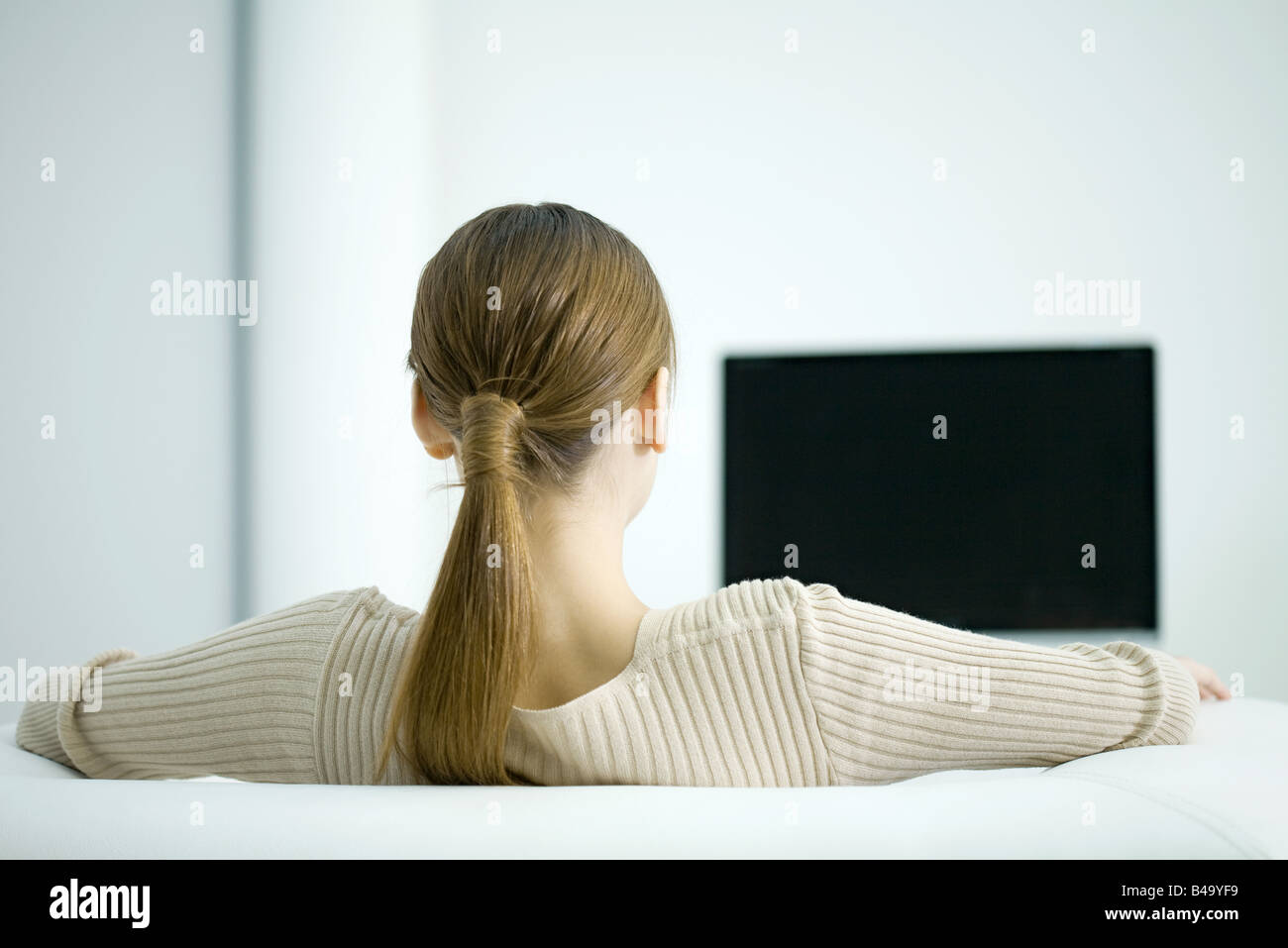 Woman watching TV, rear view Stock Photo - Alamy