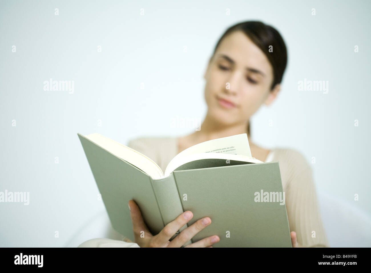 Young woman reading, focus on book in foreground Stock Photo - Alamy