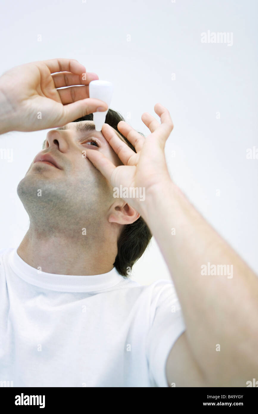 Man applying eye drops, head back Stock Photo - Alamy