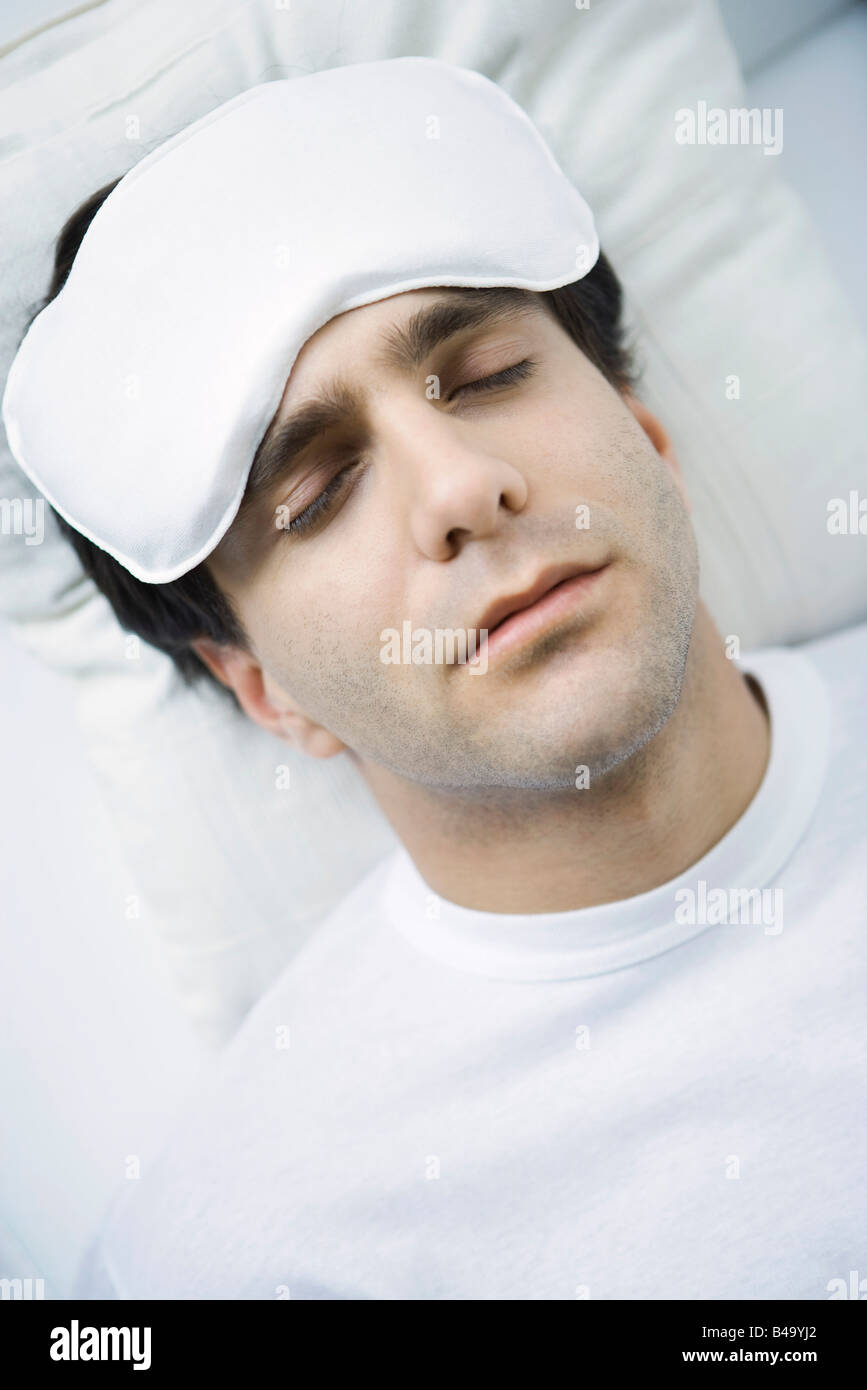 Man reclining with ice pack on his forehead, eyes closed Stock Photo ...