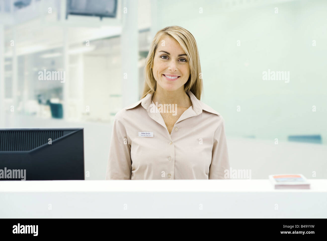 Well dressed woman standing behind counter, smiling at camera, portrait ...