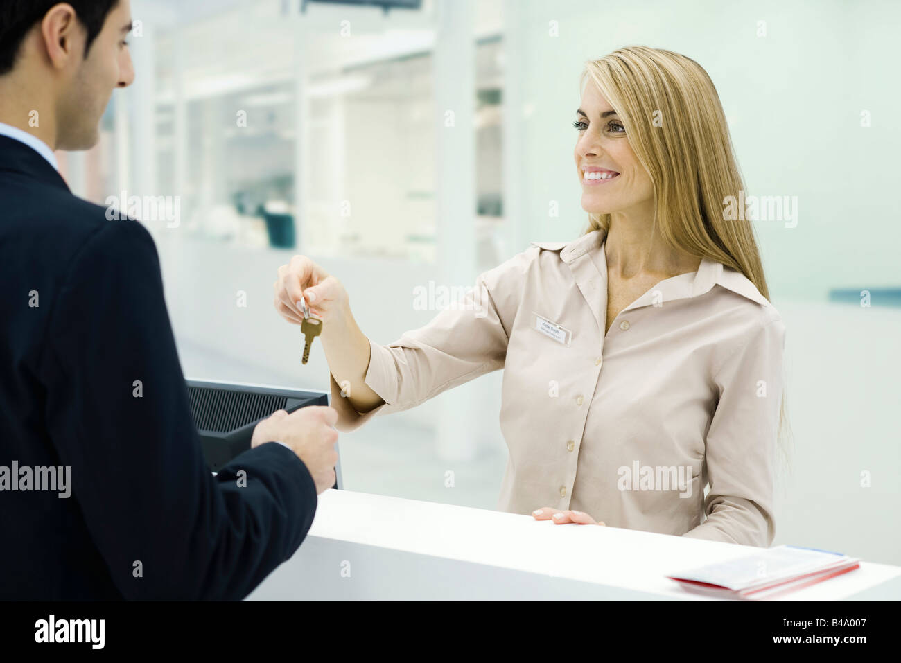 Customer service representative giving key to customer Stock Photo - Alamy