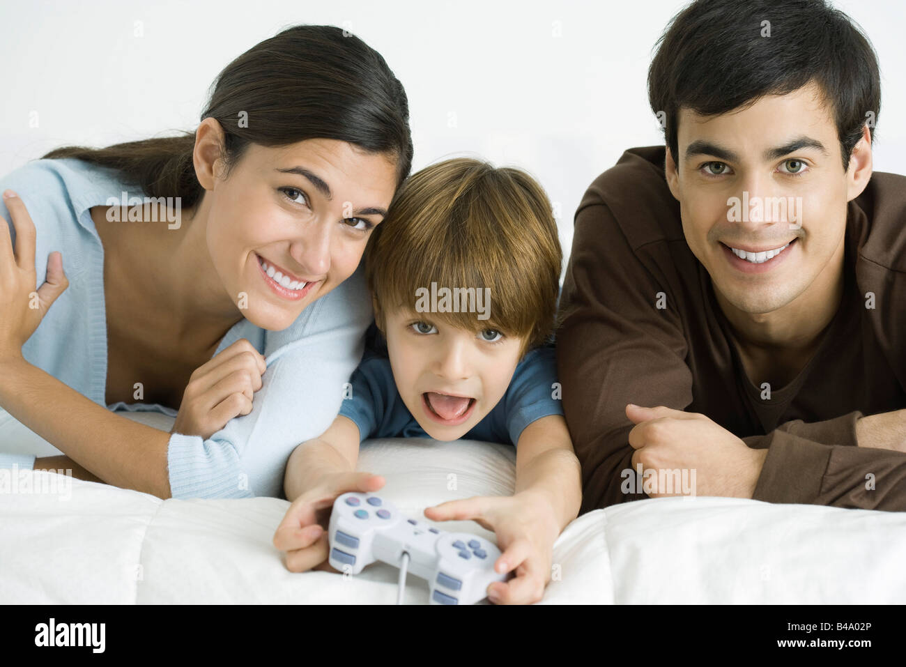 Little boy playing video game, parents watching Stock Photo - Alamy