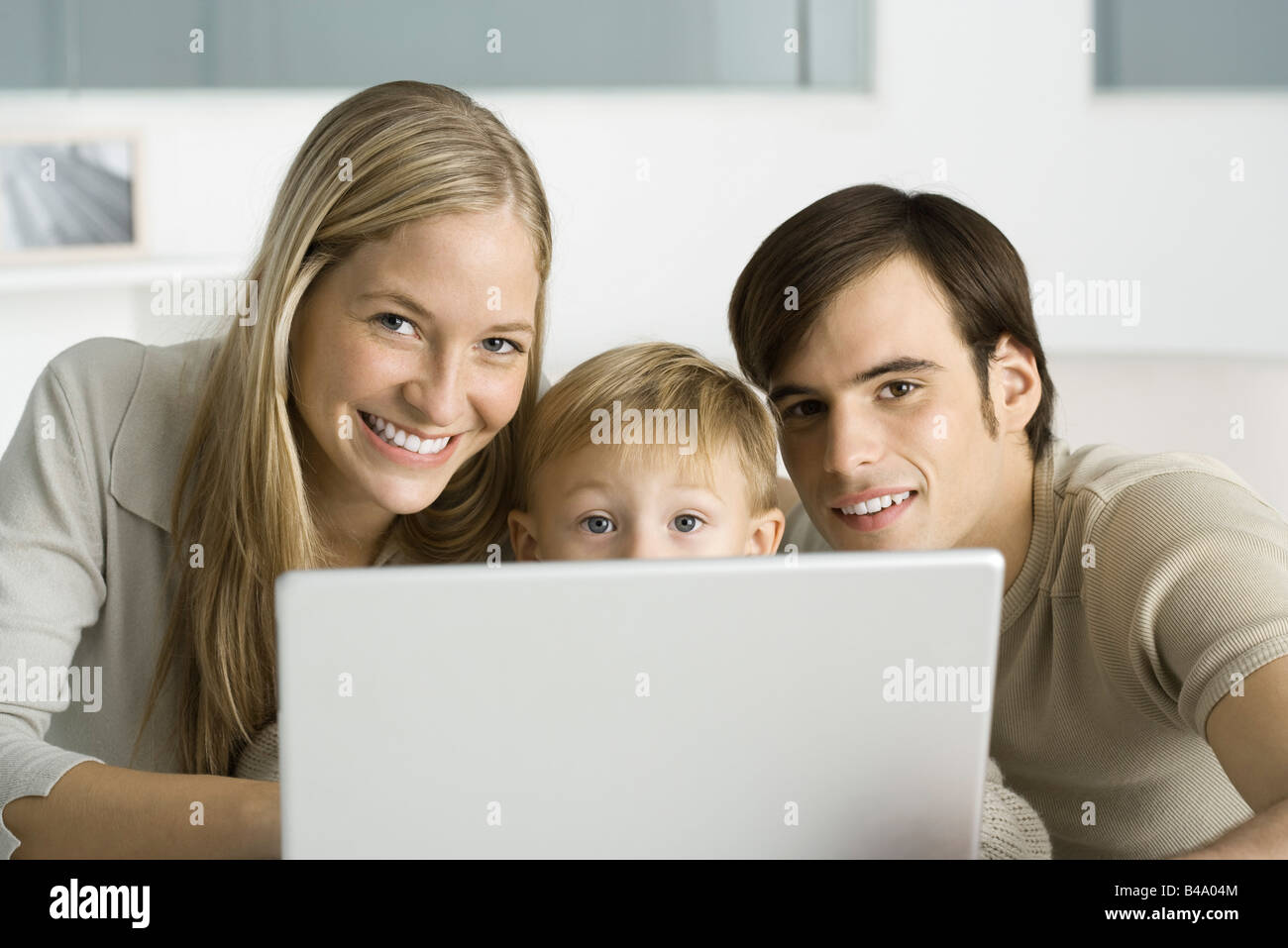Parents and young son using laptop computer, smiling at camera Stock ...