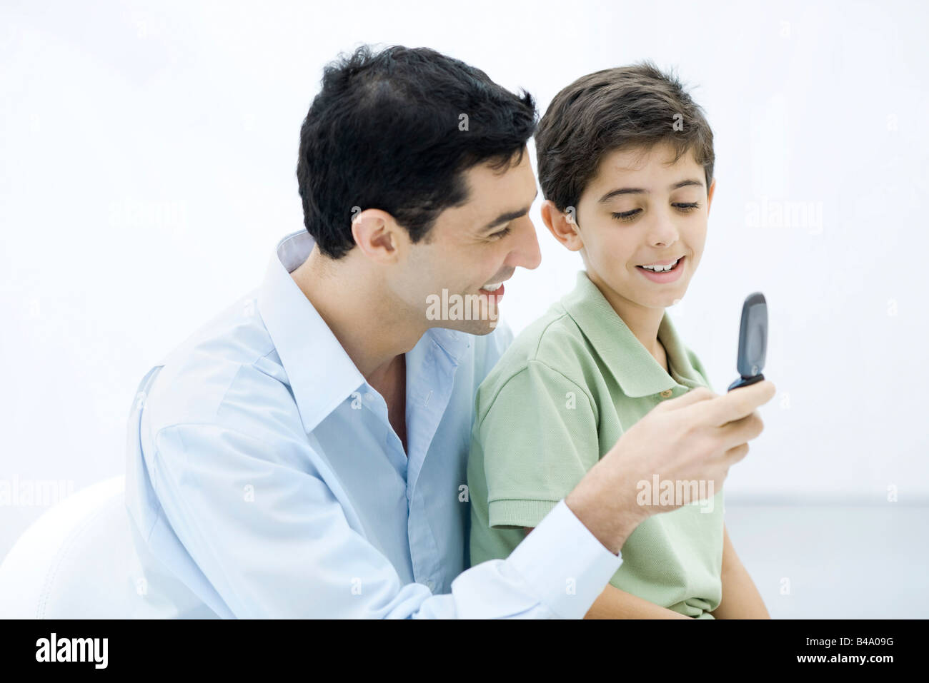 Father and son looking at cell phone together Stock Photo - Alamy