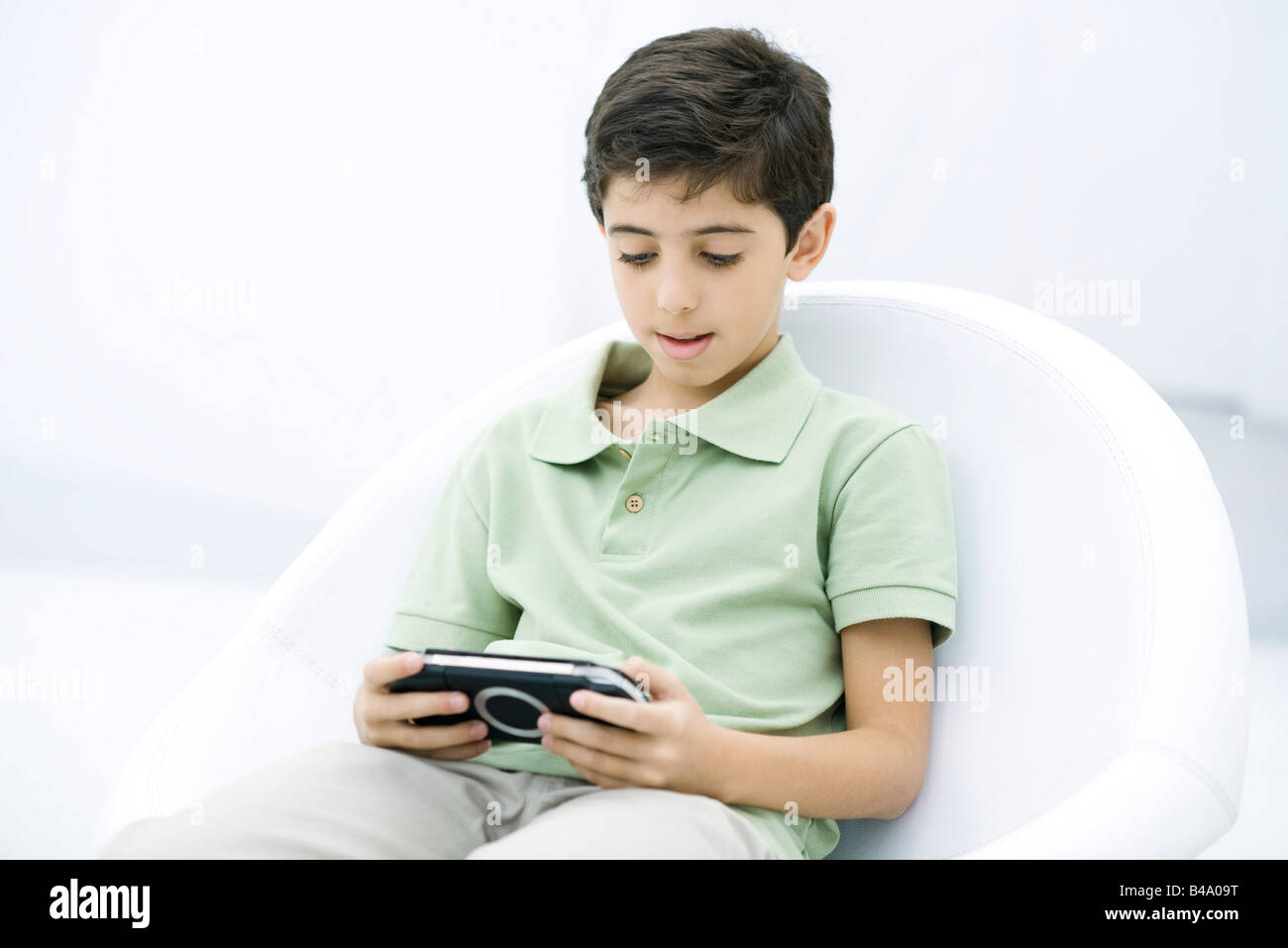 Boy playing handheld video game Stock Photo - Alamy