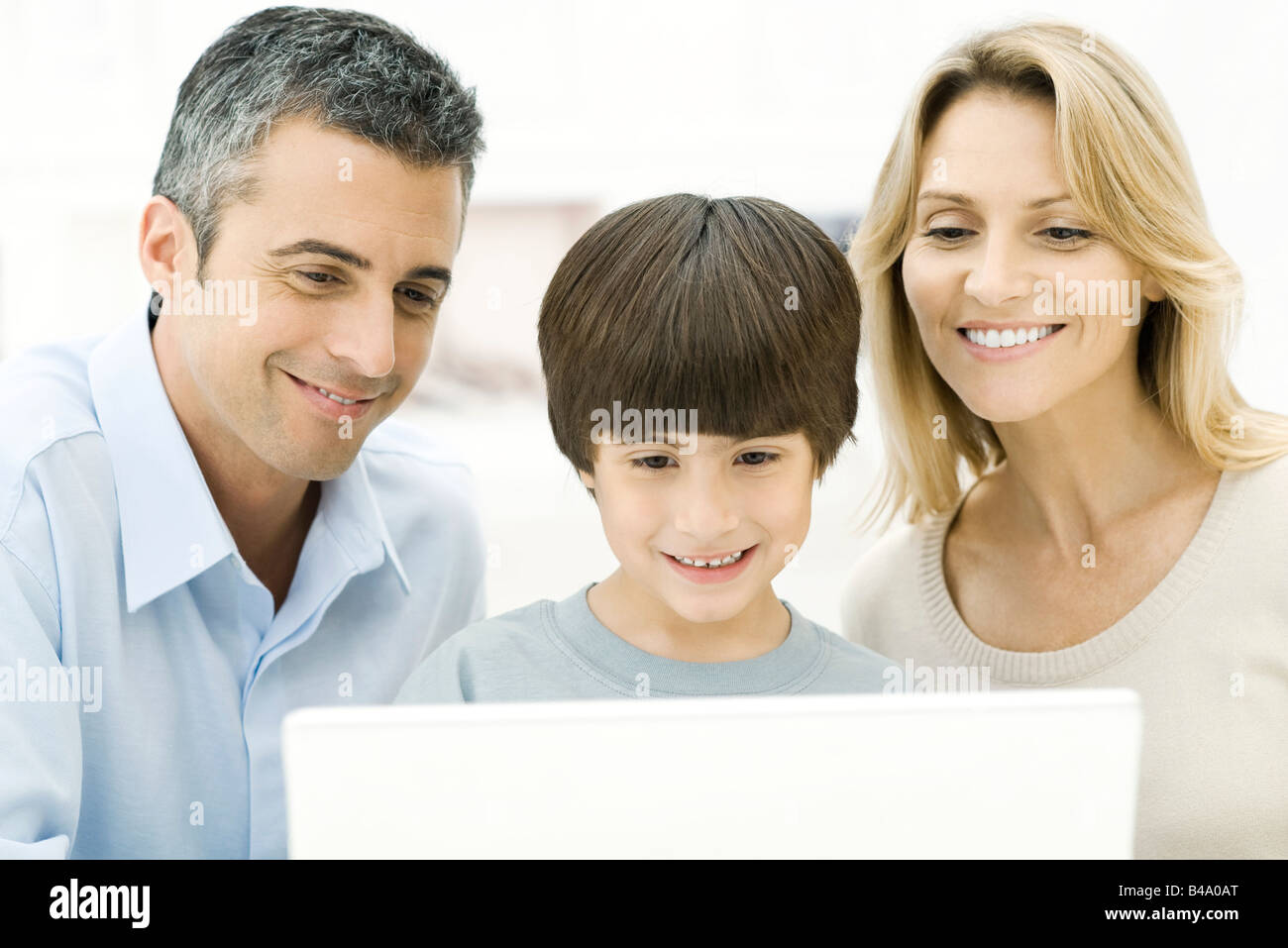 Family using laptop computer together, smiling Stock Photo - Alamy