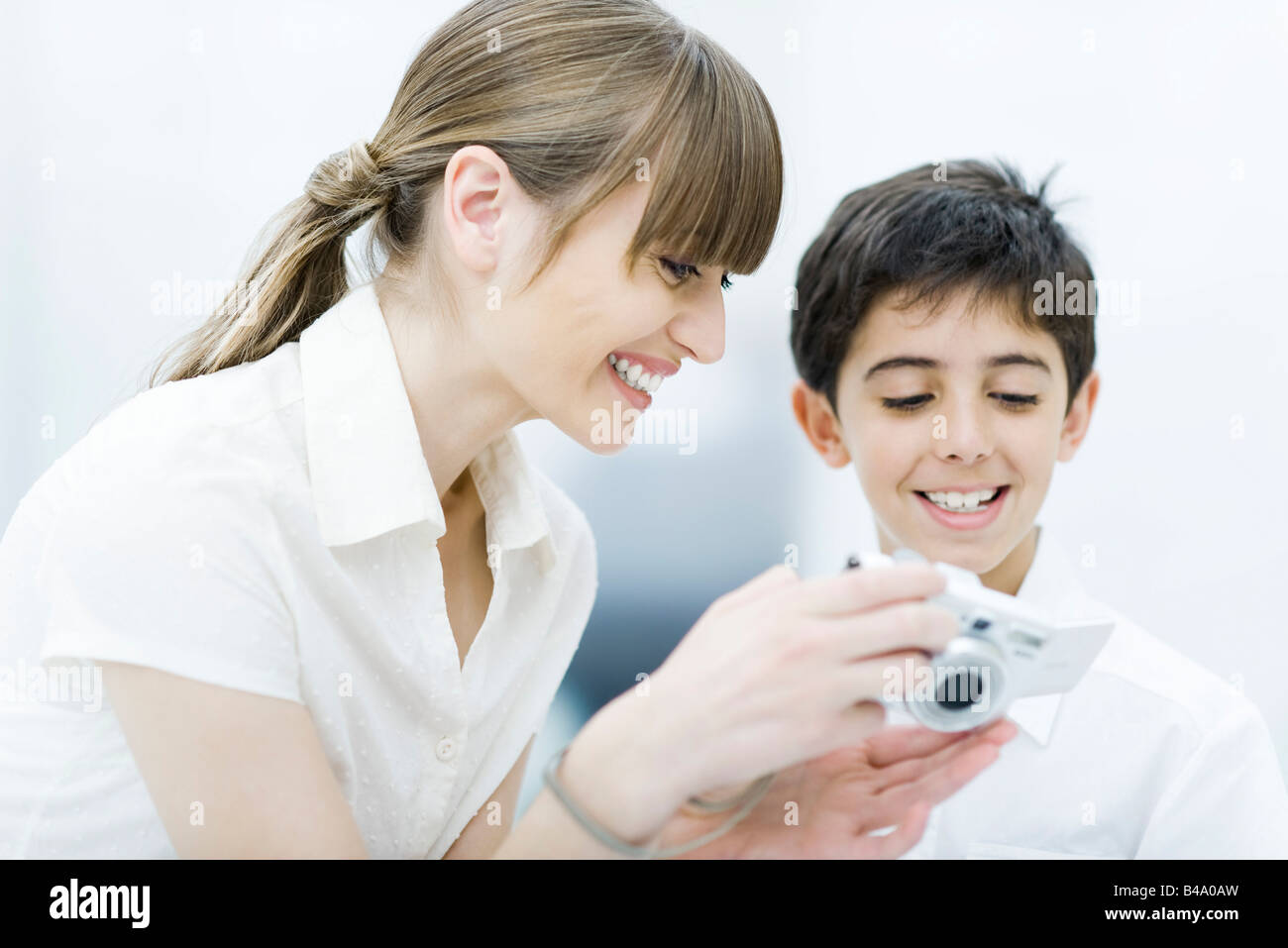 Mother and son looking at digital camera together, smiling Stock Photo ...