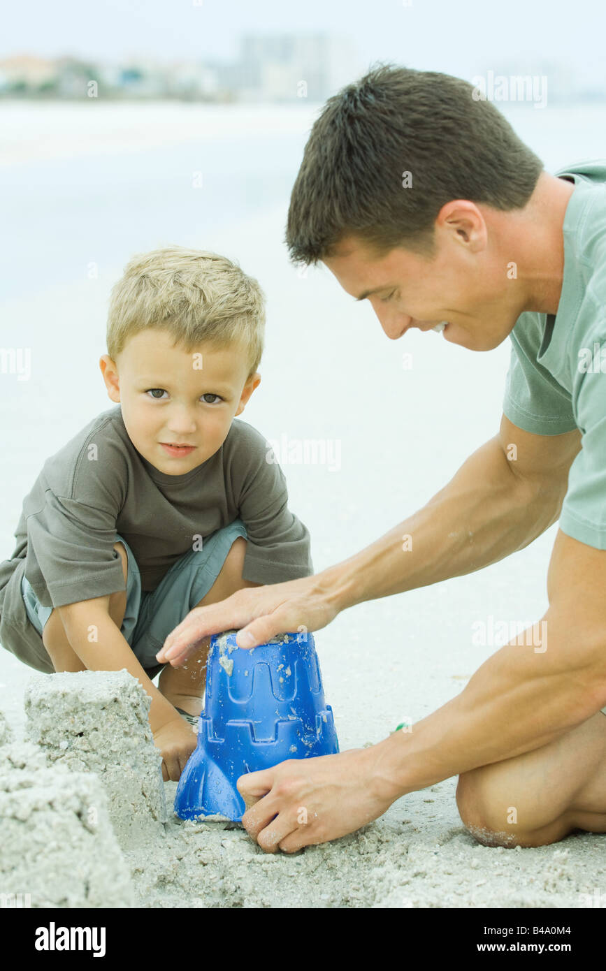 Father son playing sand bucket hi-res stock photography and images - Alamy