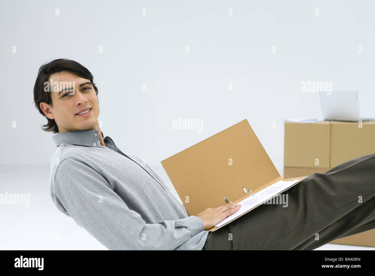 Man sitting at cardboard box desk, using laptop computer Stock Photo ...