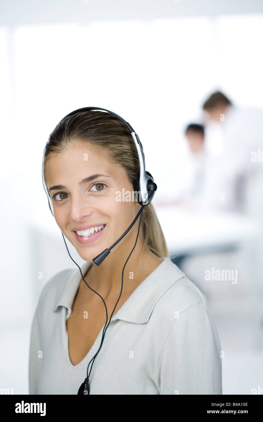 Woman wearing headset, smiling at camera, portrait Stock Photo - Alamy