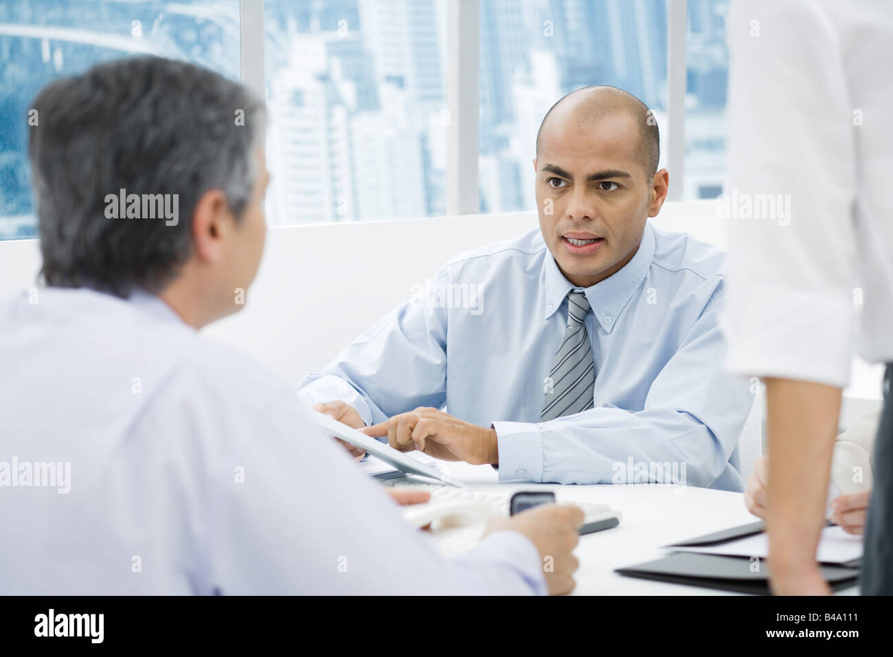Businessmen having a meeting at desk, focus on man in background Stock ...