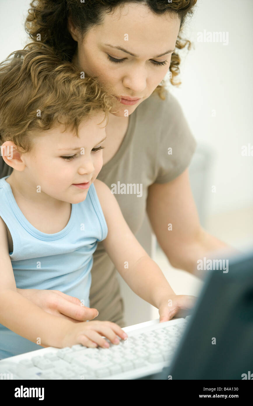Mother and toddler son typing together on keyboard Stock Photo - Alamy
