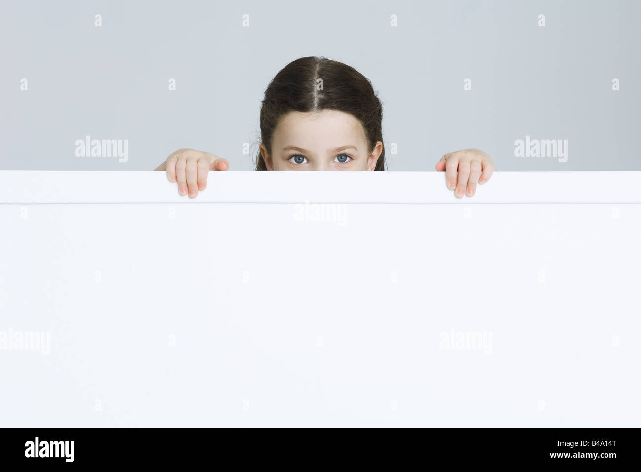 Little girl peeking over ledge at camera Stock Photo - Alamy
