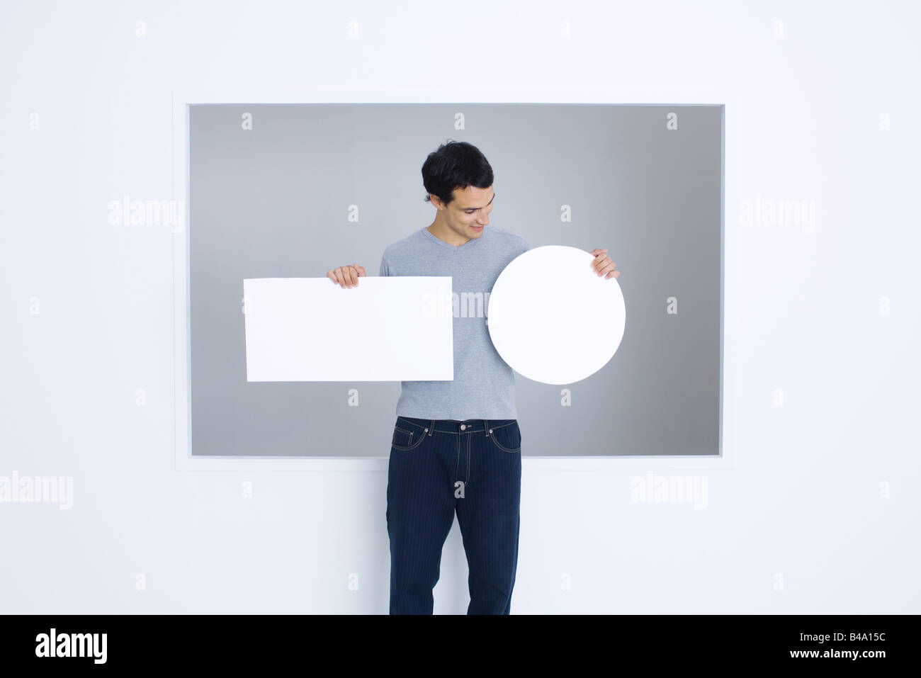 Man holding blank signs, looking down and smiling Stock Photo - Alamy